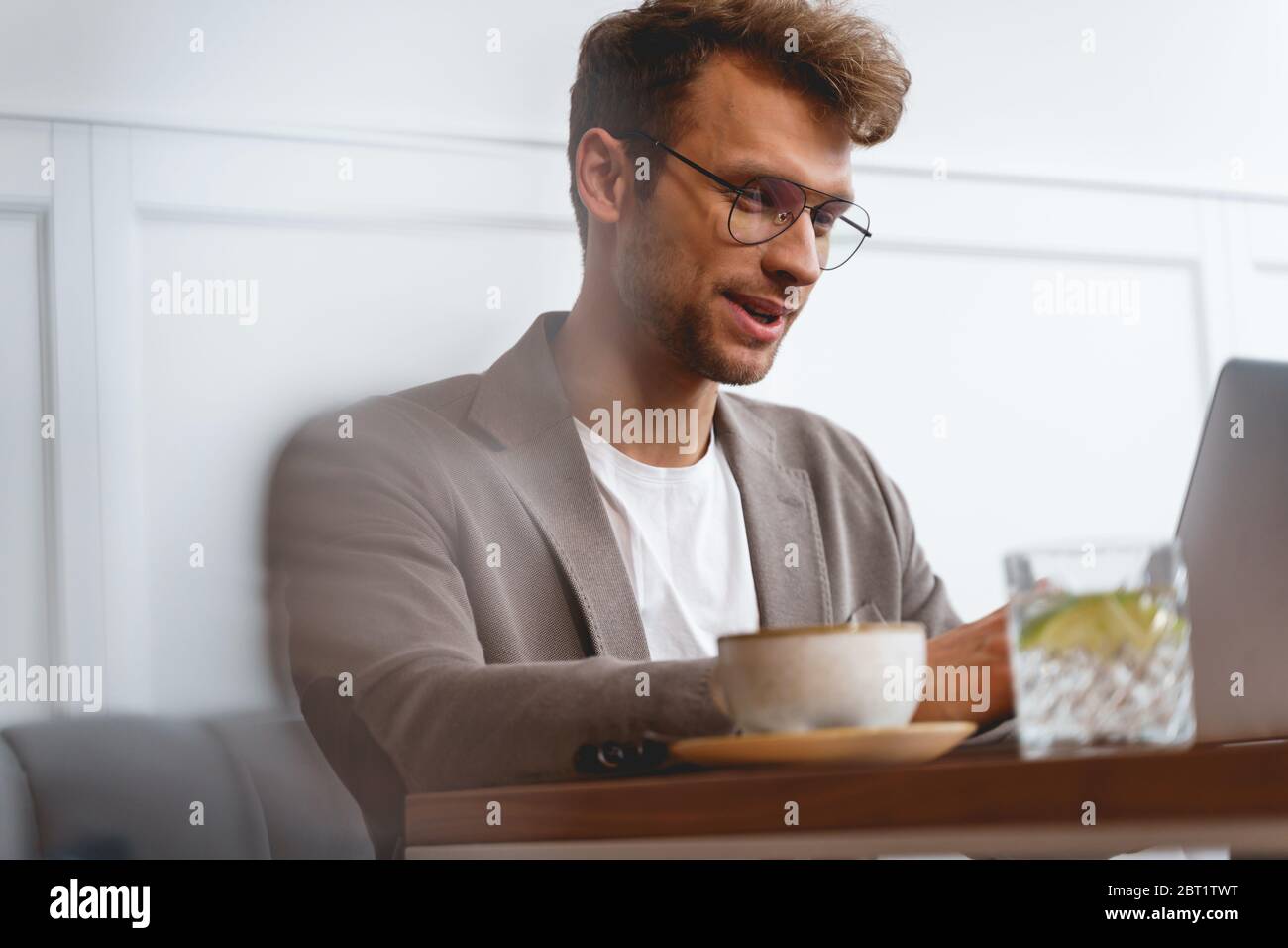 Good-looking gentleman using modern laptop in cafe Stock Photo - Alamy