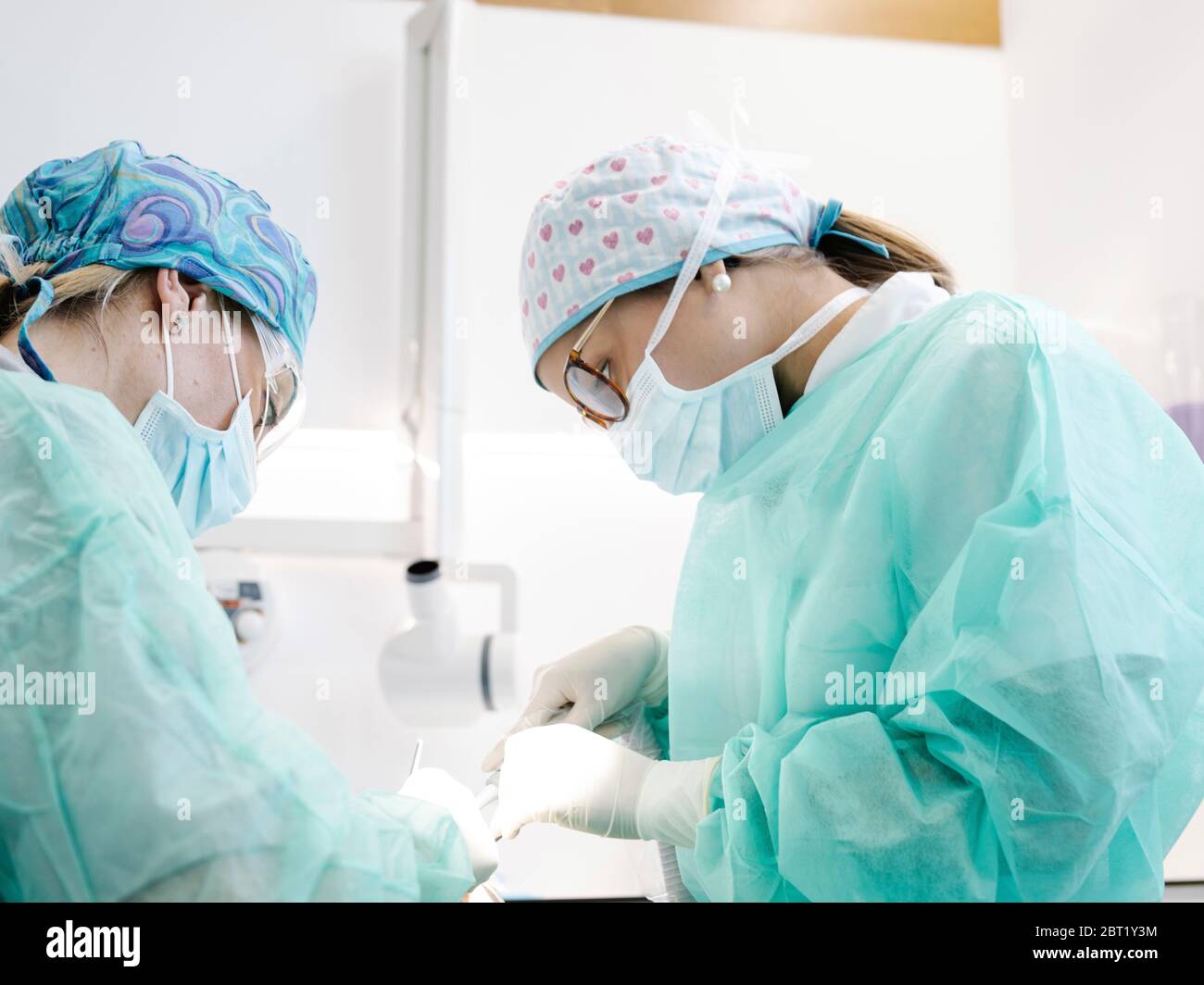 Women in masks and clean uniform performing healing procedure on ...