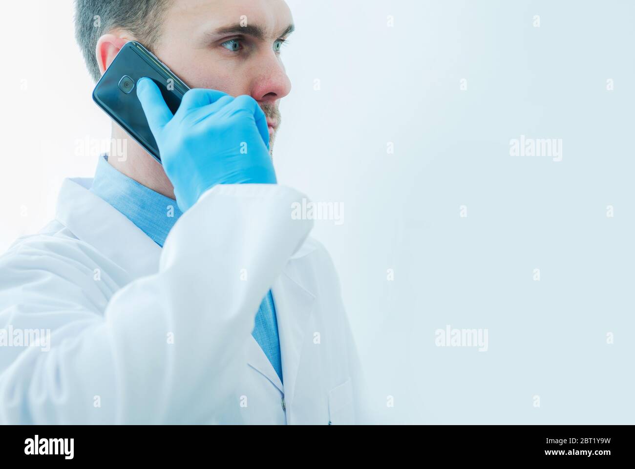 Adult Male General Practitioner In Lab Coat And Wearing Gloves Talking ...