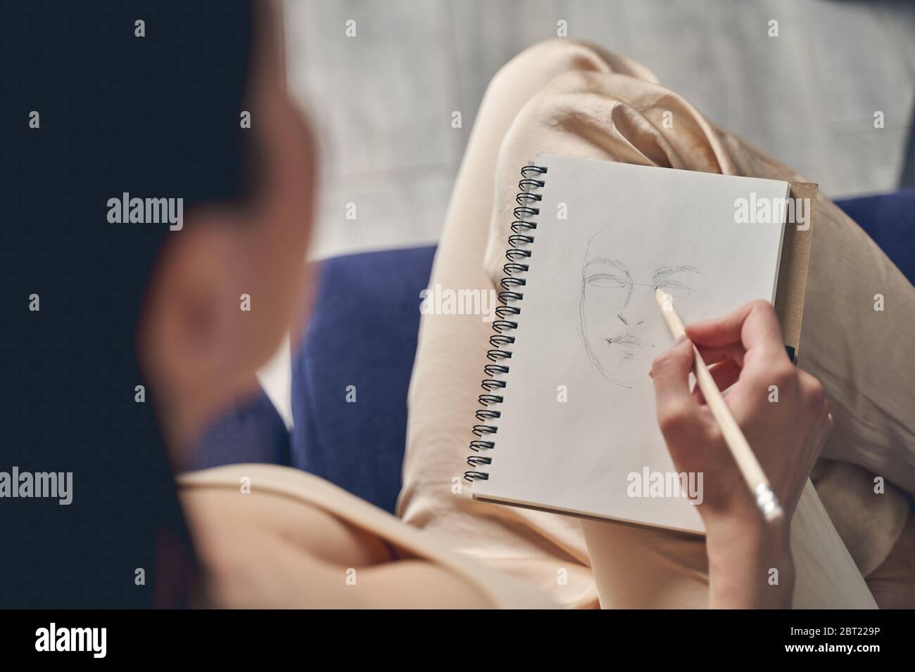 Young woman drawing in notebook at home Stock Photo - Alamy