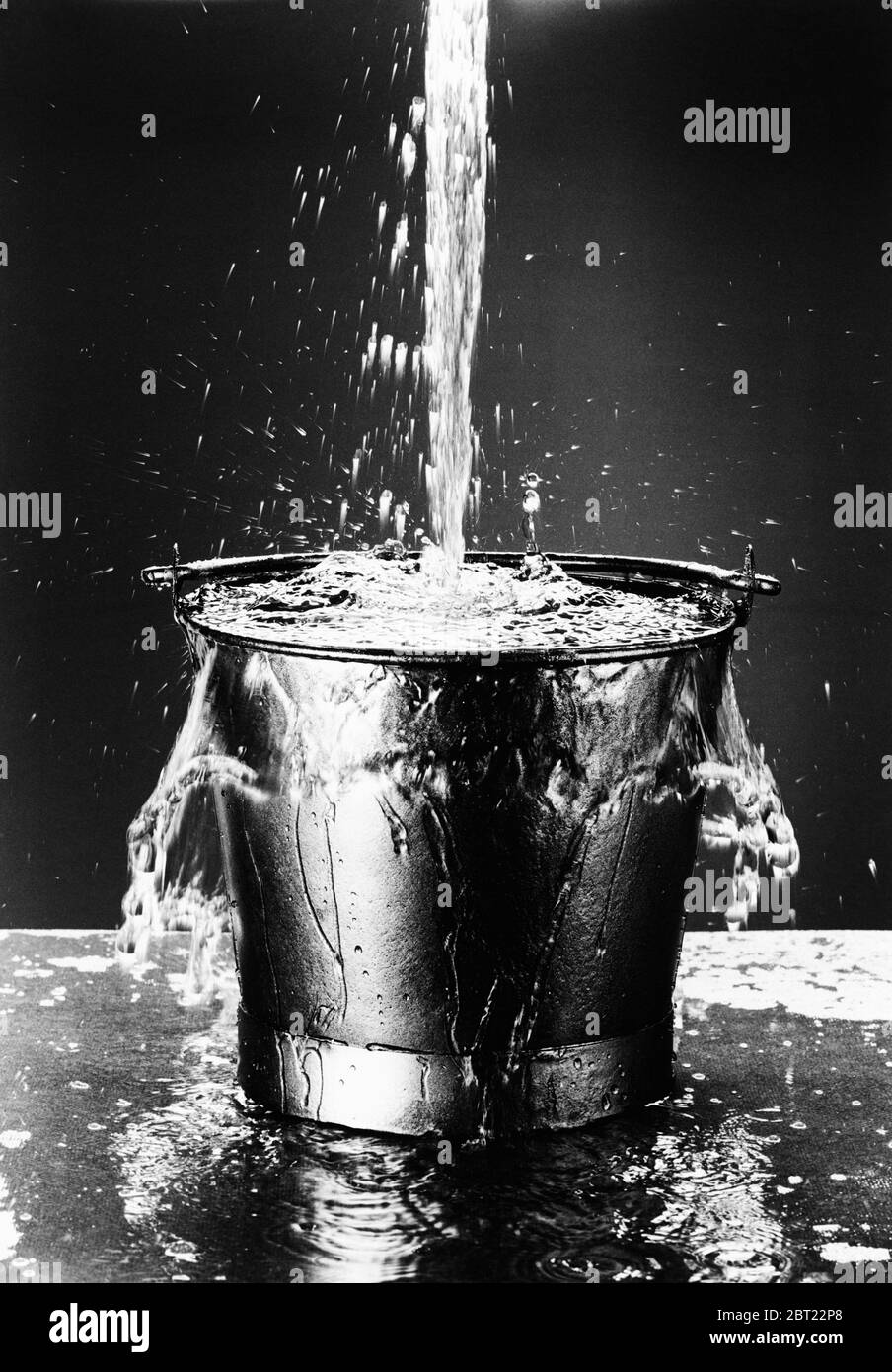 Black and white photo of water falling into bucket Stock Photo - Alamy