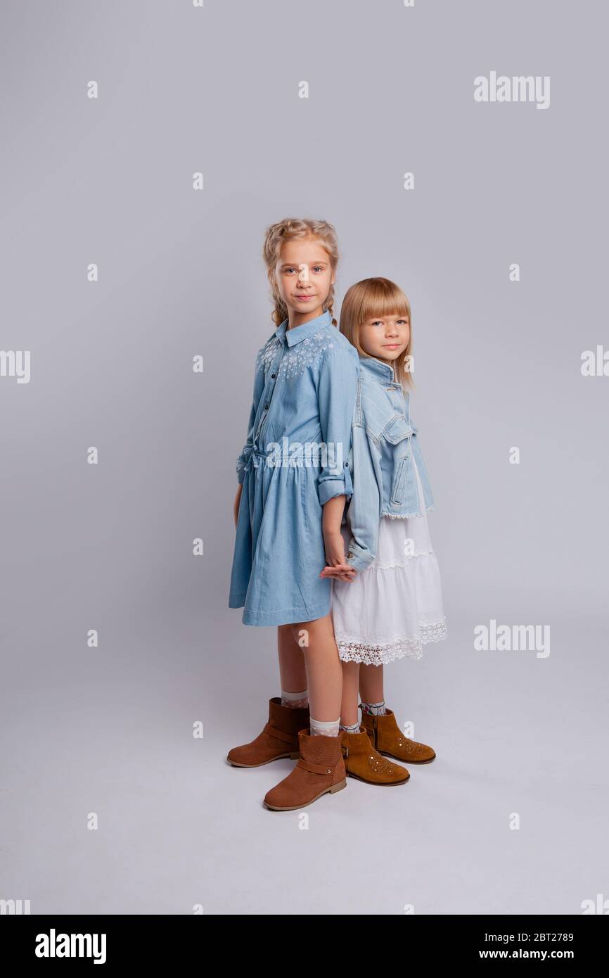Two girls stand with their backs to each other Stock Photo - Alamy