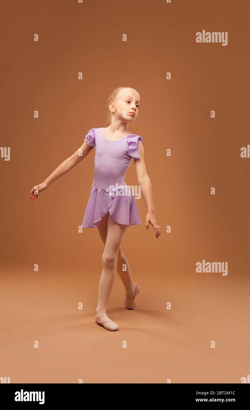 cute girl in a purple dress shows elements of ballet Stock Photo - Alamy