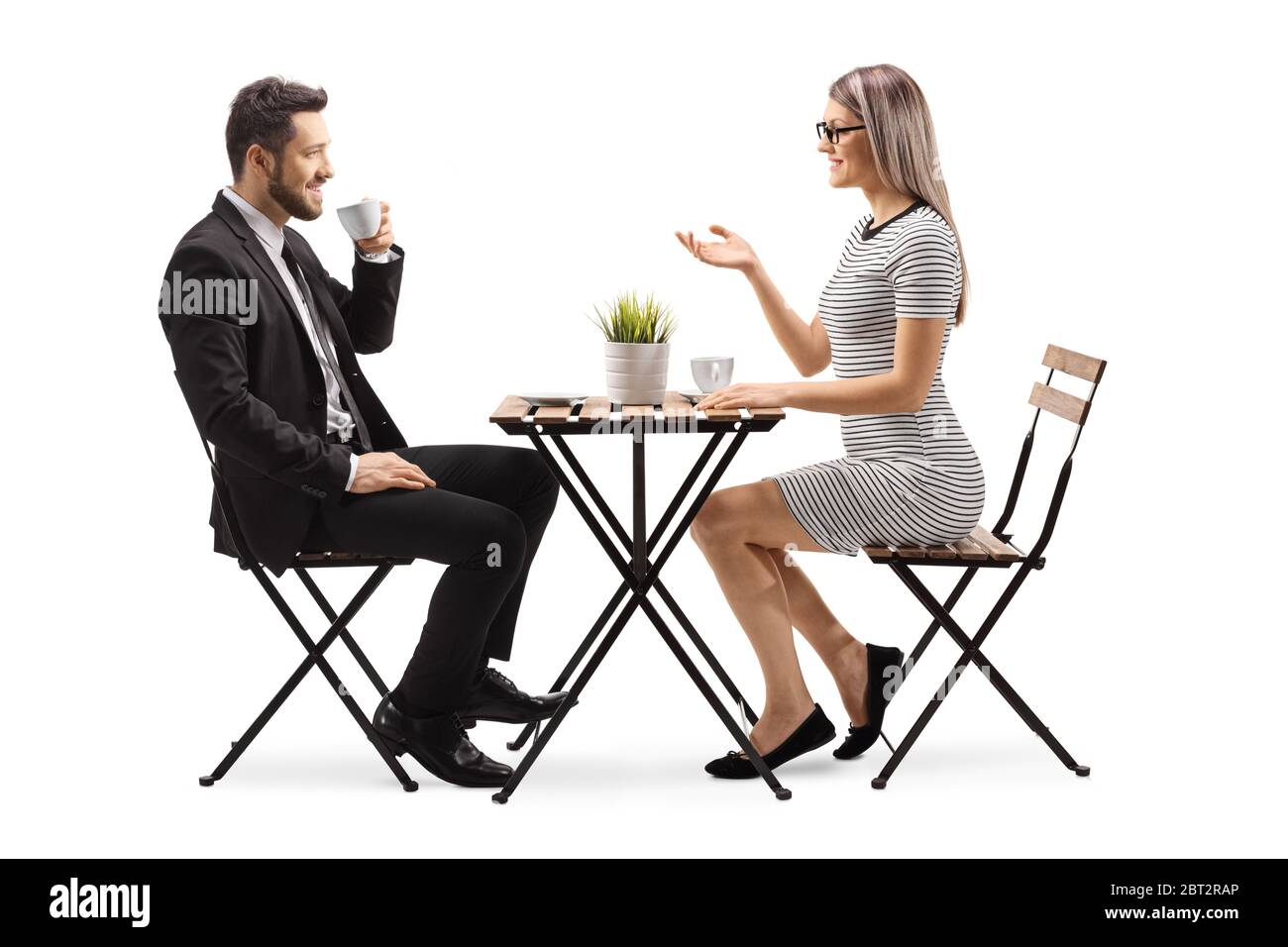 Full length profile shot of a young man and woman in a cafe talking and ...