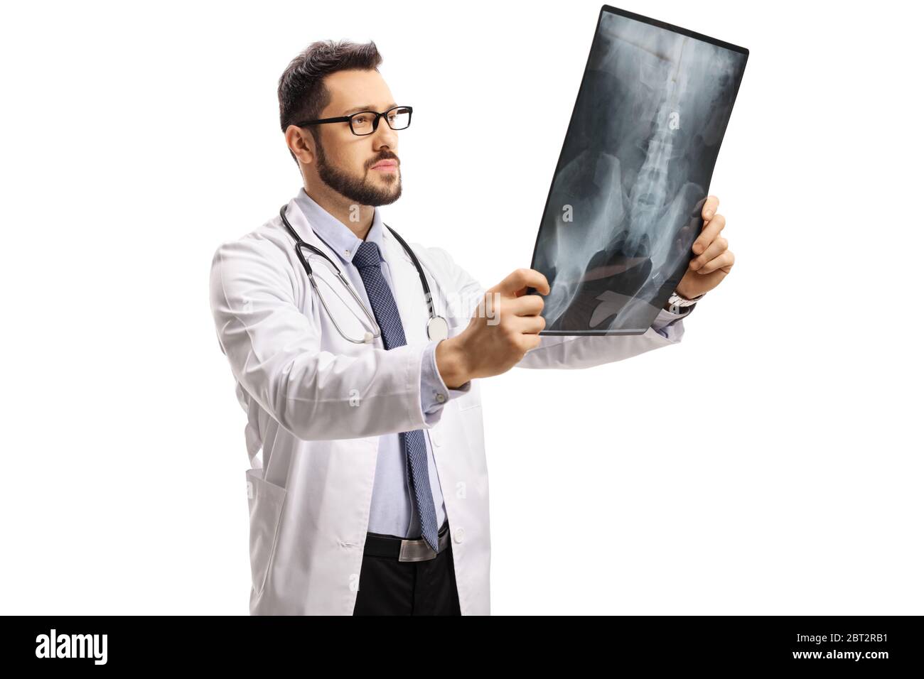 Young male doctor examining an x ray scan isolated on white background ...