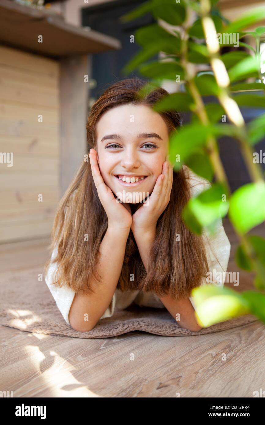 Beautiful smiling girl lies on the sunlit floor Stock Photo - Alamy