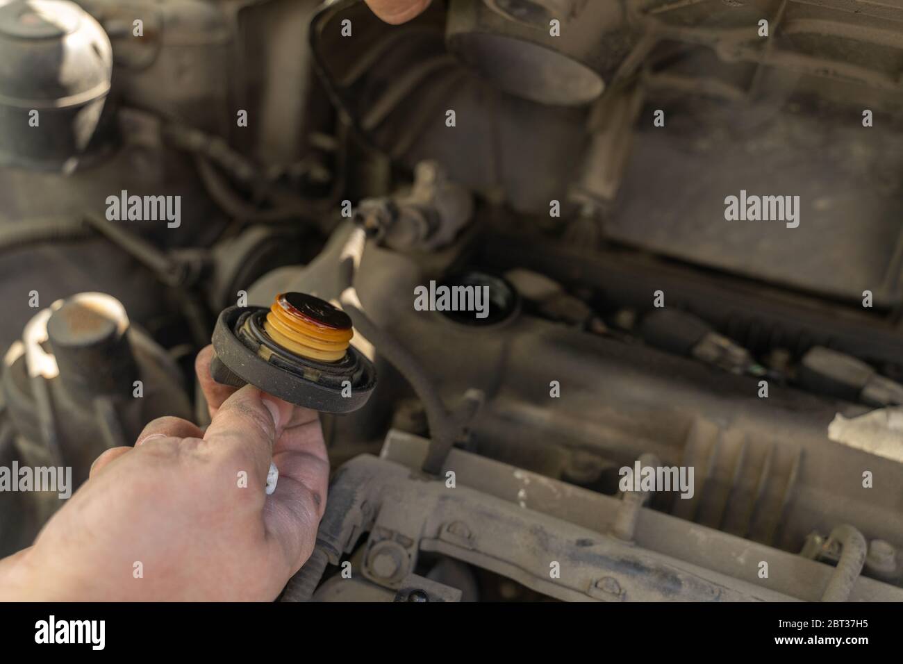 Auto mechanic works in the garage. Repair. Removing engine cover for ...