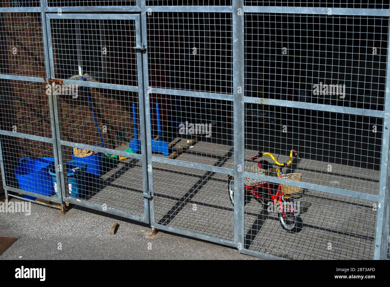 Childs tricycle locked away in compound Stock Photo - Alamy