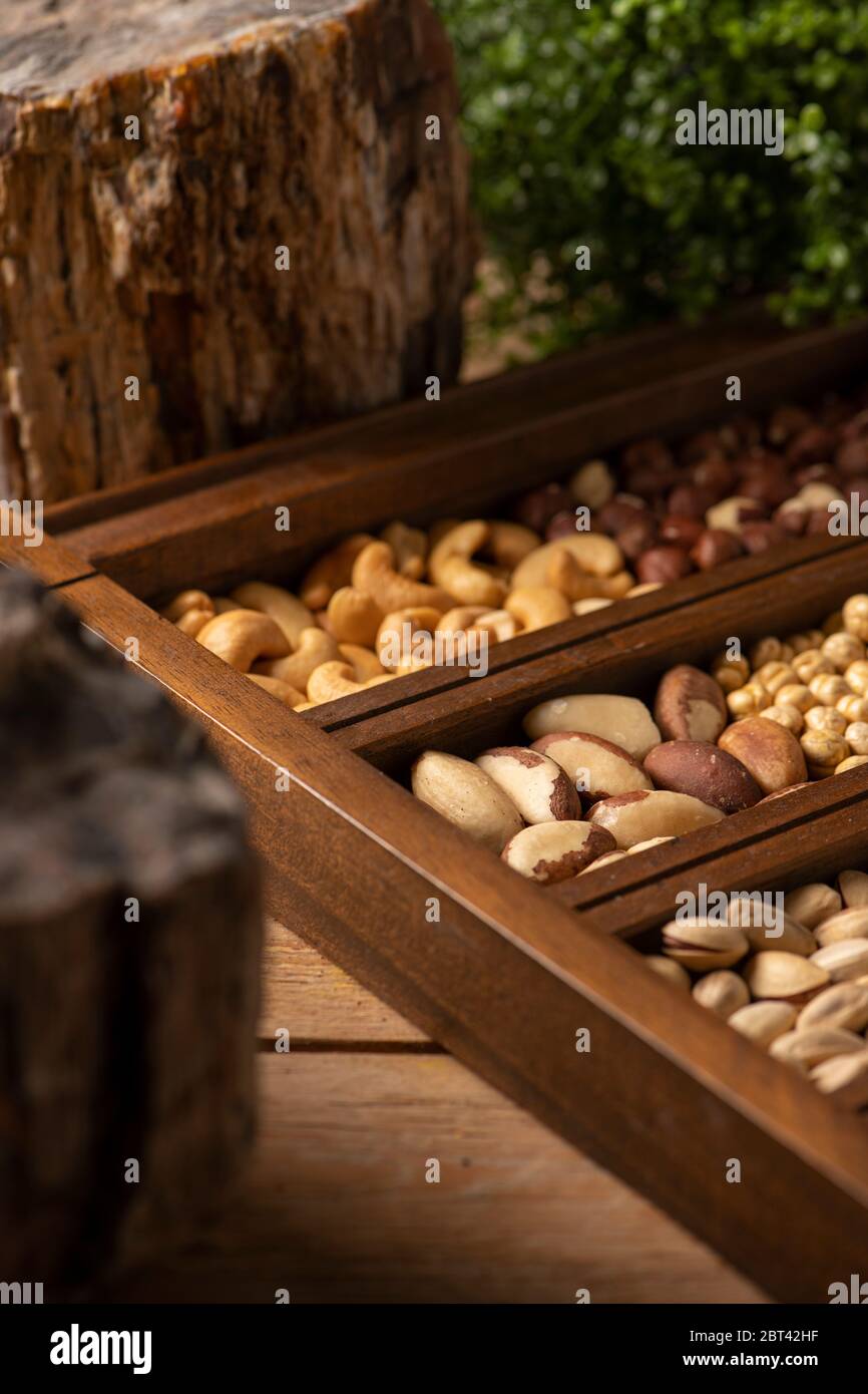Fossilized forest and mixed nuts in a wooden box on a wooden surface ...