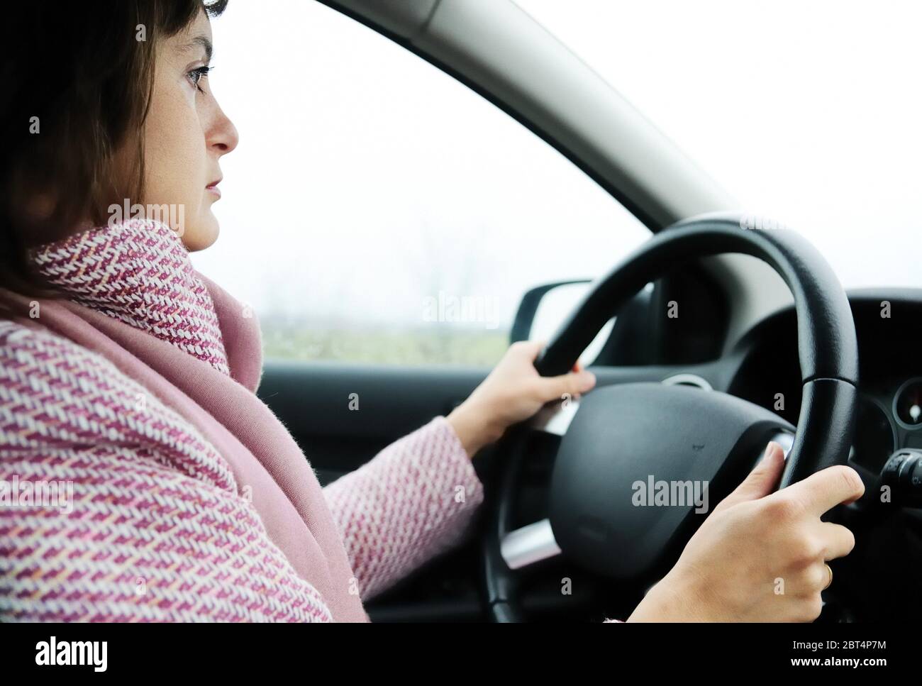 Young business woman driving car in rain (focus on face Stock Photo - Alamy