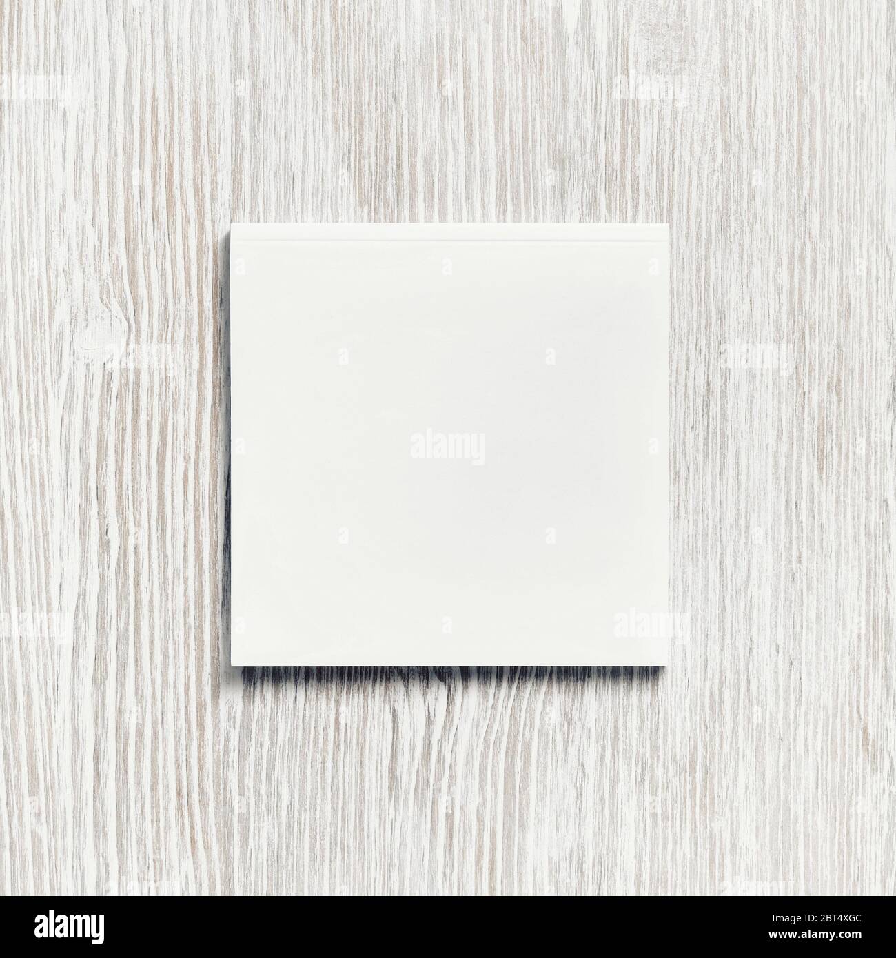 Blank square notepad on light wood table background. Responsive design ...