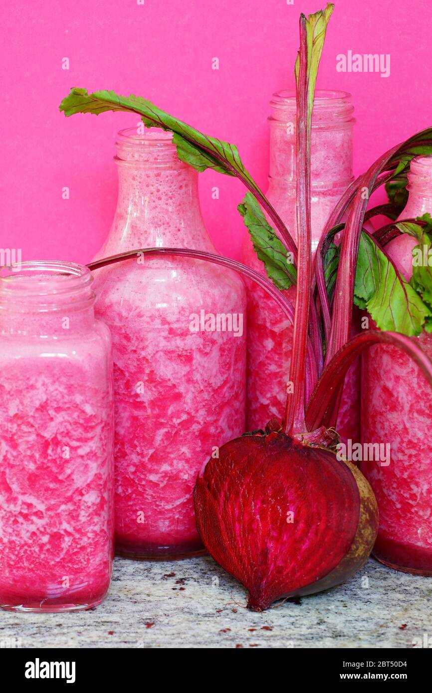 Glass bottles filled with colorful fresh homemade beet and pineapple ...