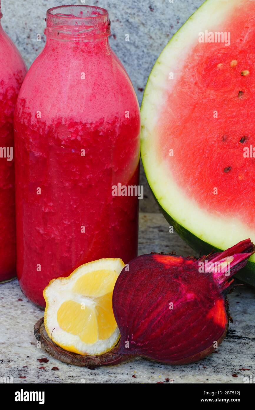 Glass bottles filled with colorful fresh homemade beet and watermelon ...