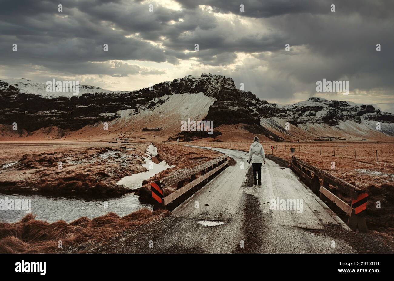Woman walking along road, Iceland Stock Photo - Alamy