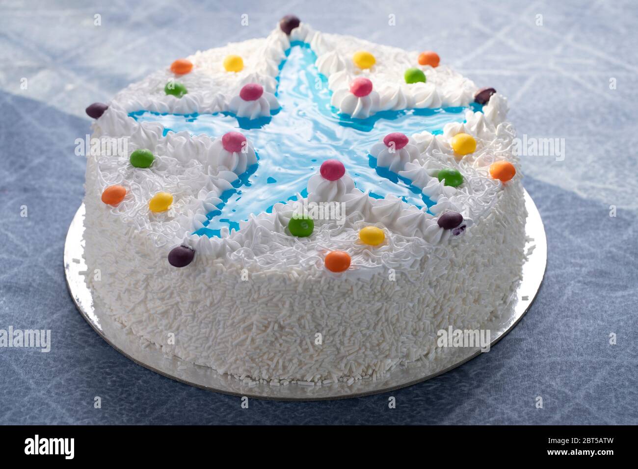 A vanilla cheese cake with a blue star shape on top Stock Photo - Alamy