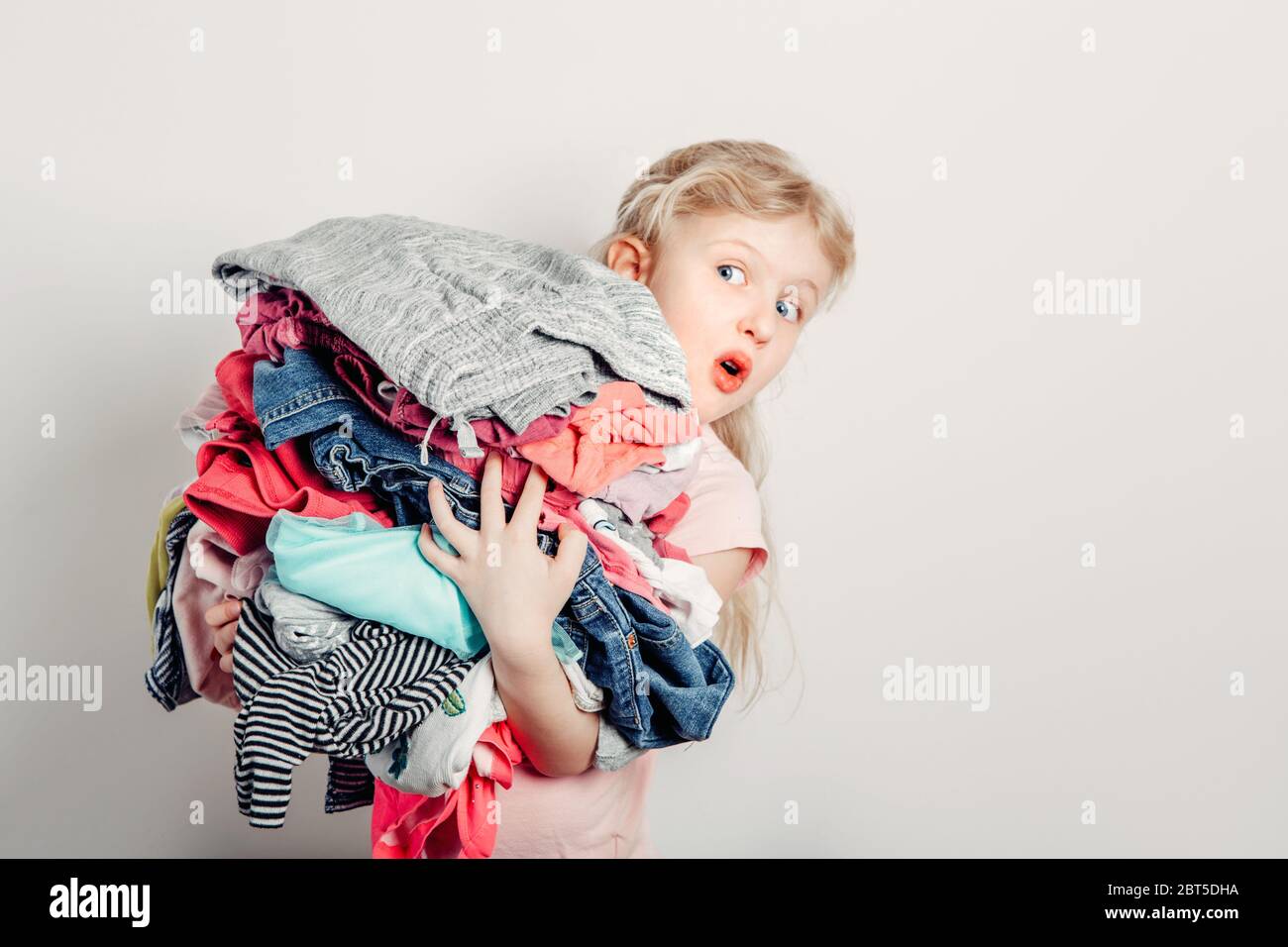 Mommy little helper. Cute Caucasian girl sorting clothes. Adorable ...