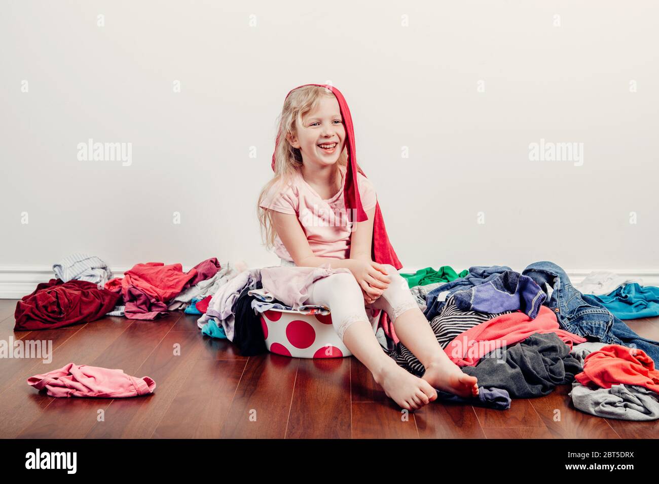 Mommy little helper. Cute Caucasian girl sorting clothes. Adorable ...
