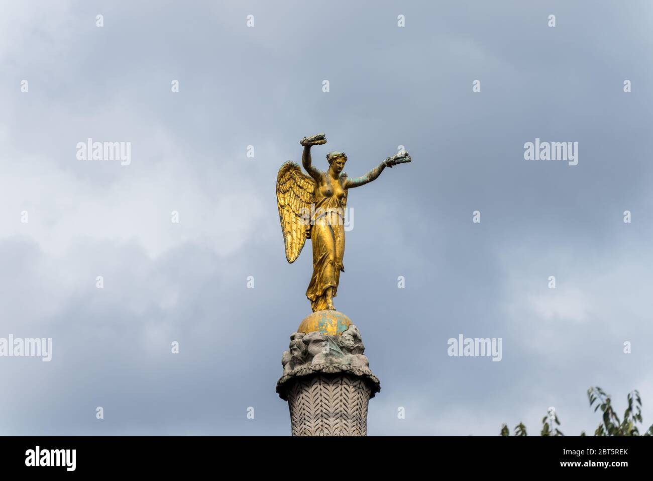 A golden winged statue on the top of a column in the downtown of Paris ...
