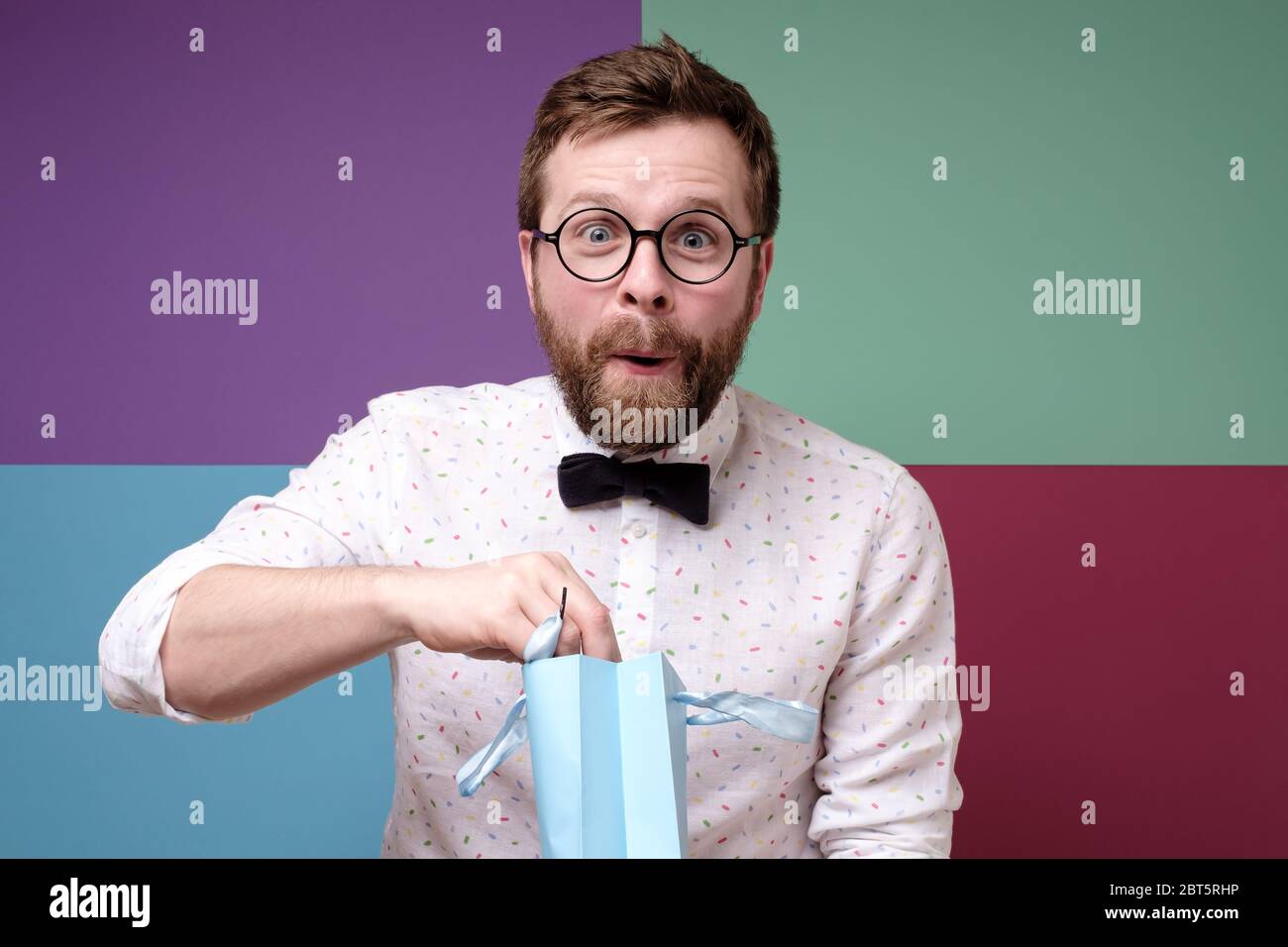 Attractive man is surprised by an unexpected surprise, he takes a gift ...