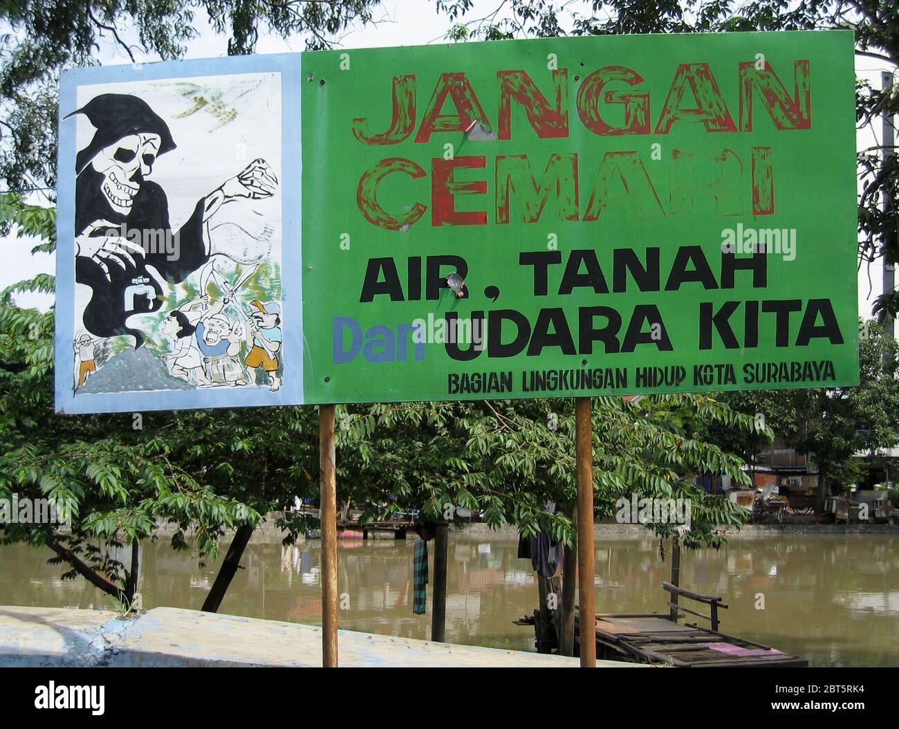polluted water sign board in slum area next to the kalimas river ...