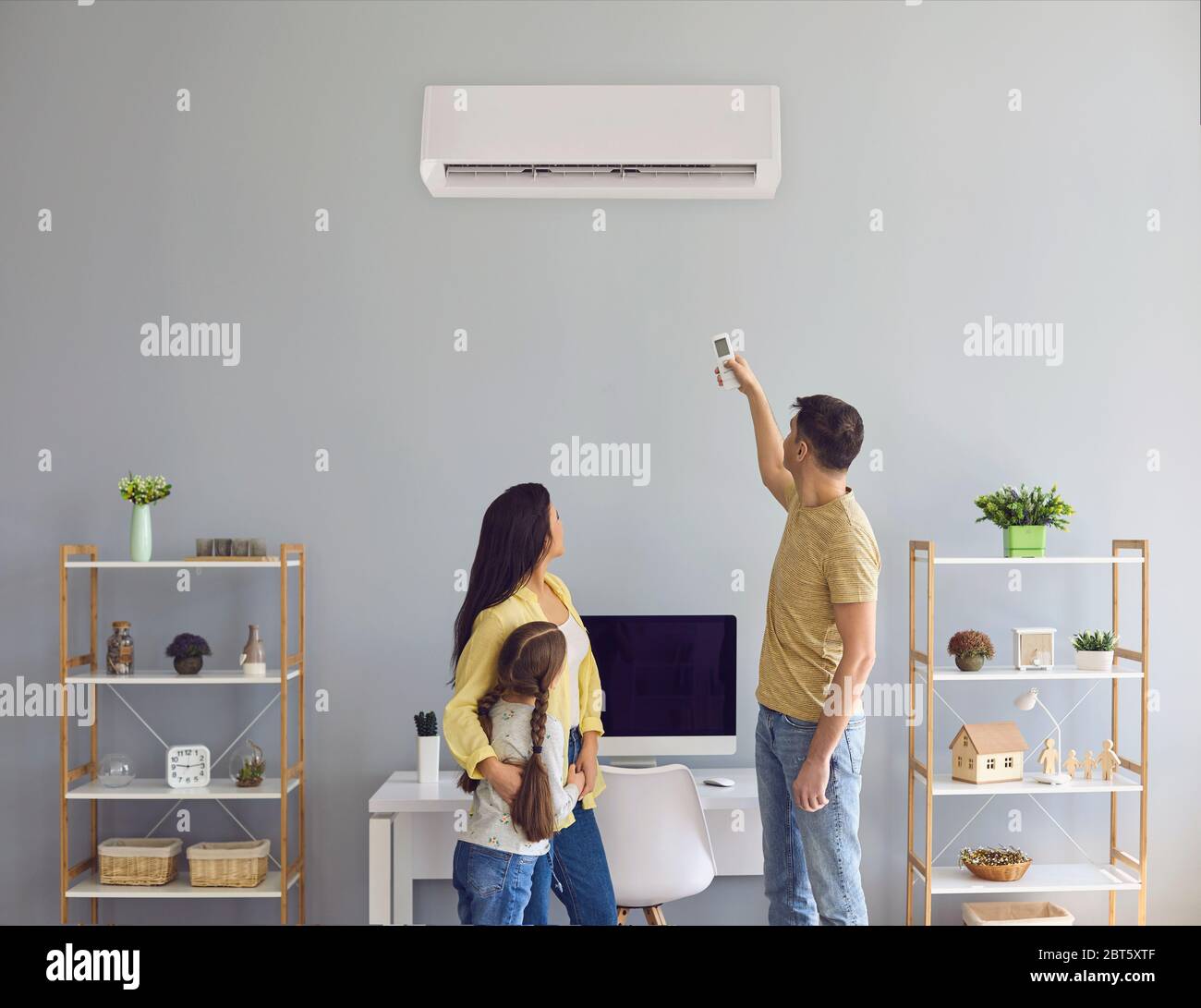 The family uses air conditioning at home. Back view. Climatic air ...