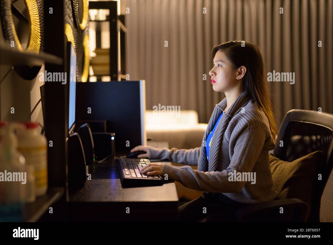 Young Asian woman working overtime at home late at night Stock Photo ...