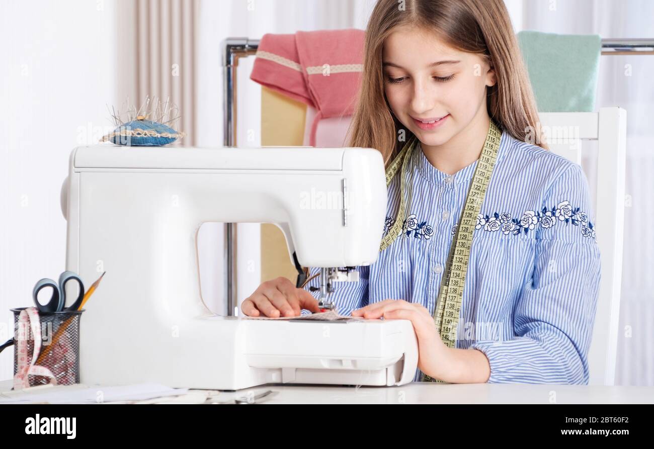 Teenager girl working with sewing machine as a tailor Stock Photo - Alamy
