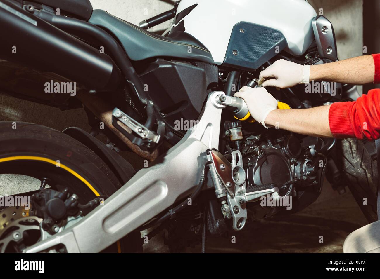 Mechanic repairman doing maintenance or repairing, fixing on motorcycle ...