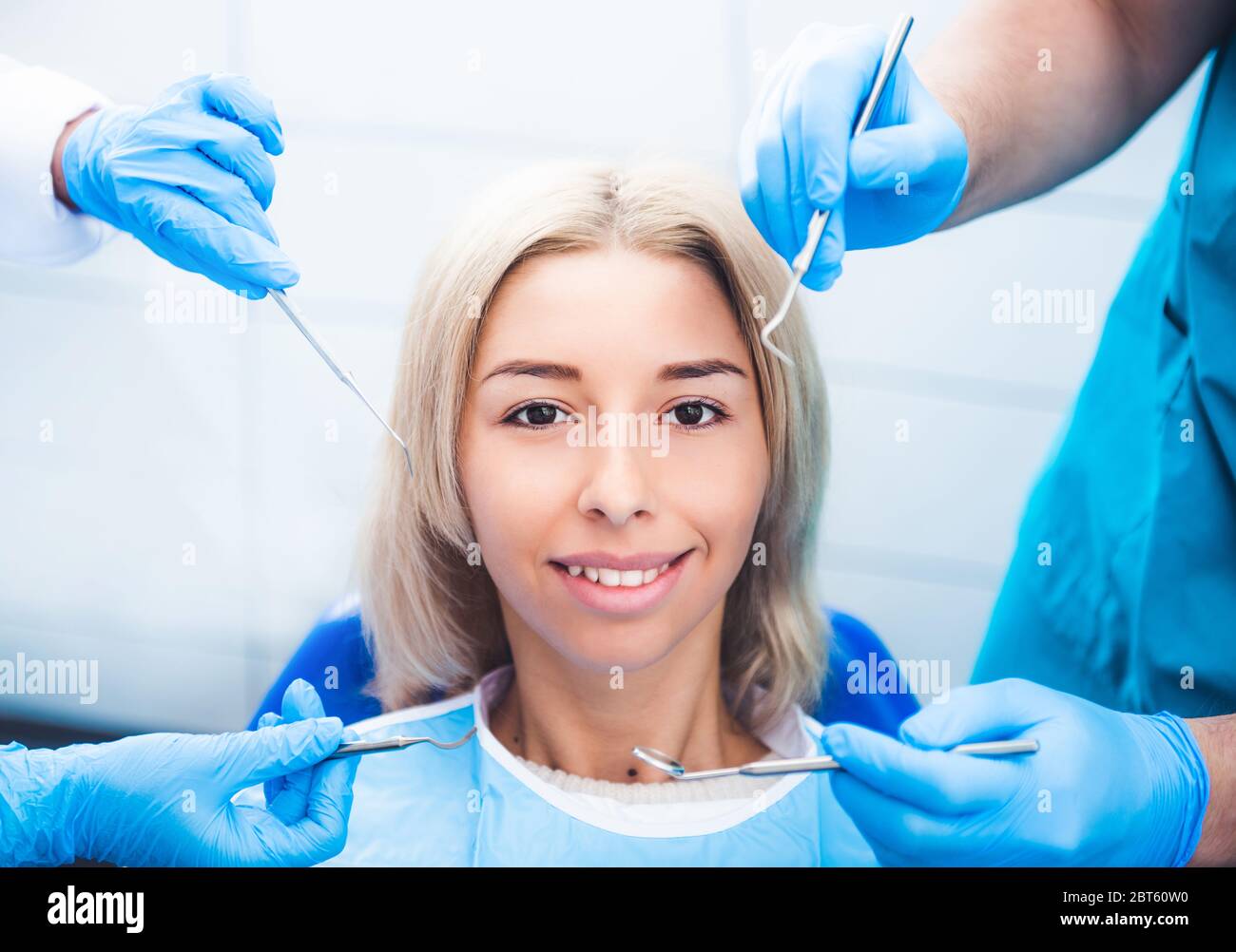 Dentists examinating blond smiling girl Stock Photo - Alamy