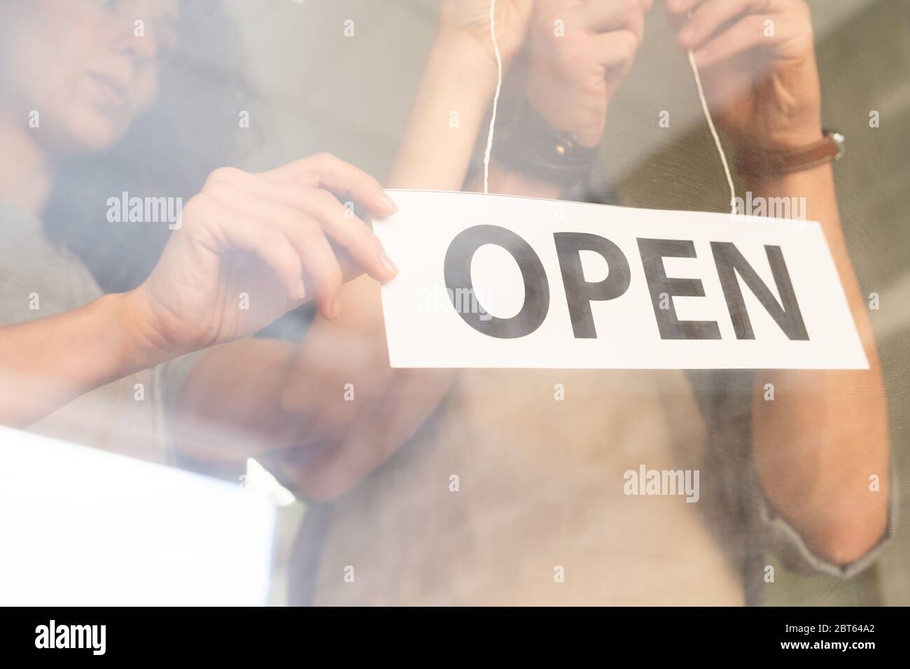 Women hanging open sign hi-res stock photography and images - Alamy