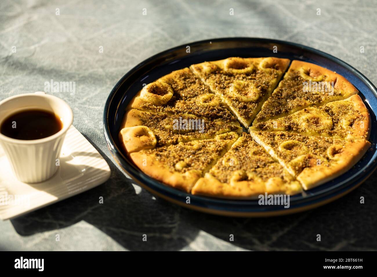 Zaatar manakish on a hot plate with an Arabic coffee, a popular ...