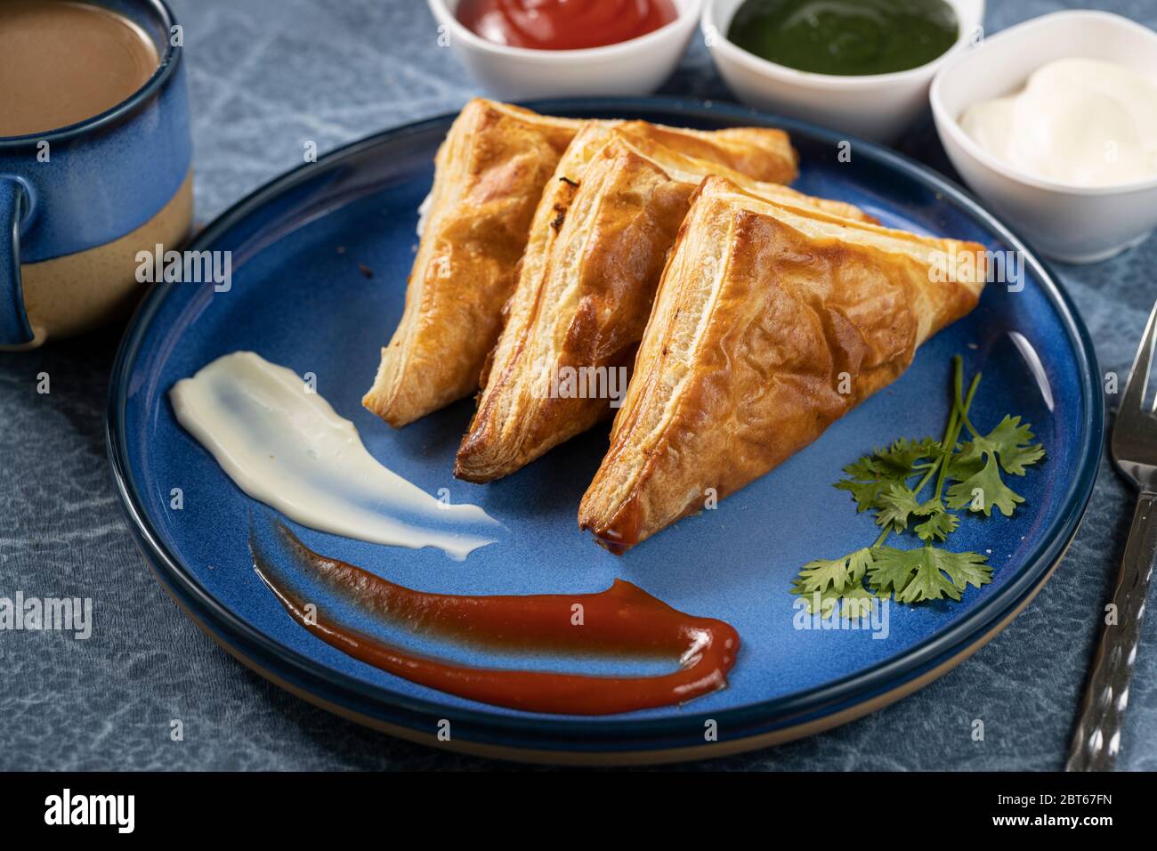 chicken or vegetable puffs on a blue plate with tomato sauce, Green ...