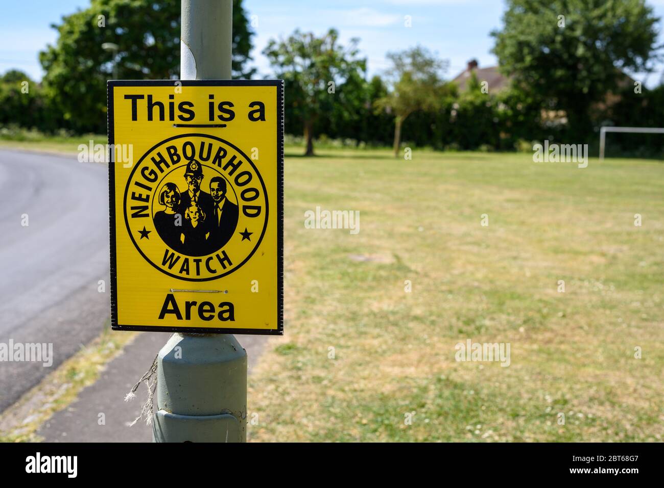 neighbourhood watch sign by the side of a playground in a village ...