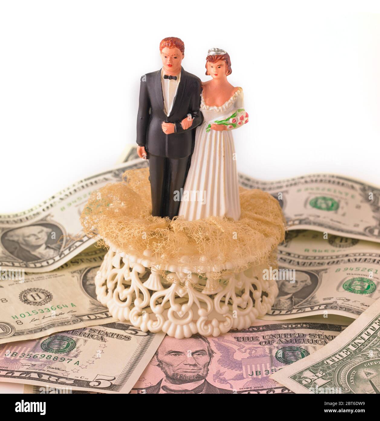 Bride and Groom wedding figures on top of pile of US Dollar banknotes ...