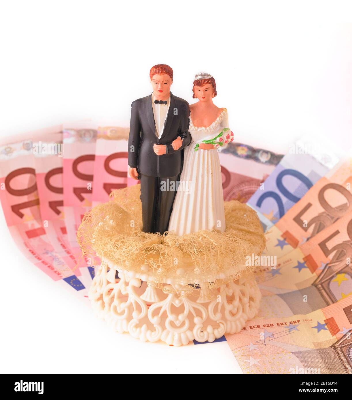 Bride and Groom traditional wedding figures on pile of Euro banknotes ...