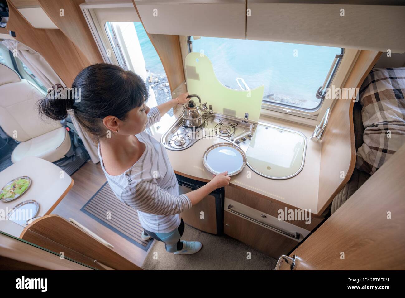 Woman cooking in camper, motorhome RV interior. Family vacation travel ...