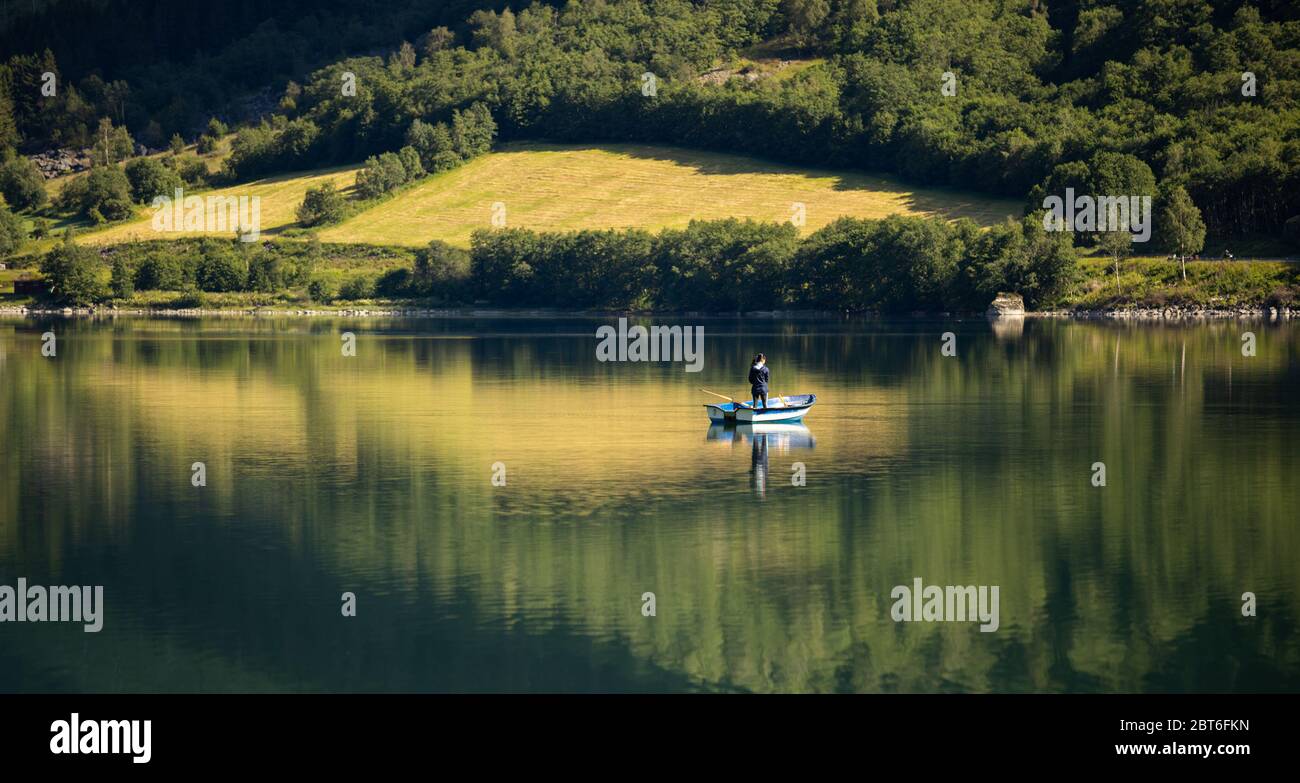 Woman fishing on a boat. Beautiful Nature Norway natural landscape ...