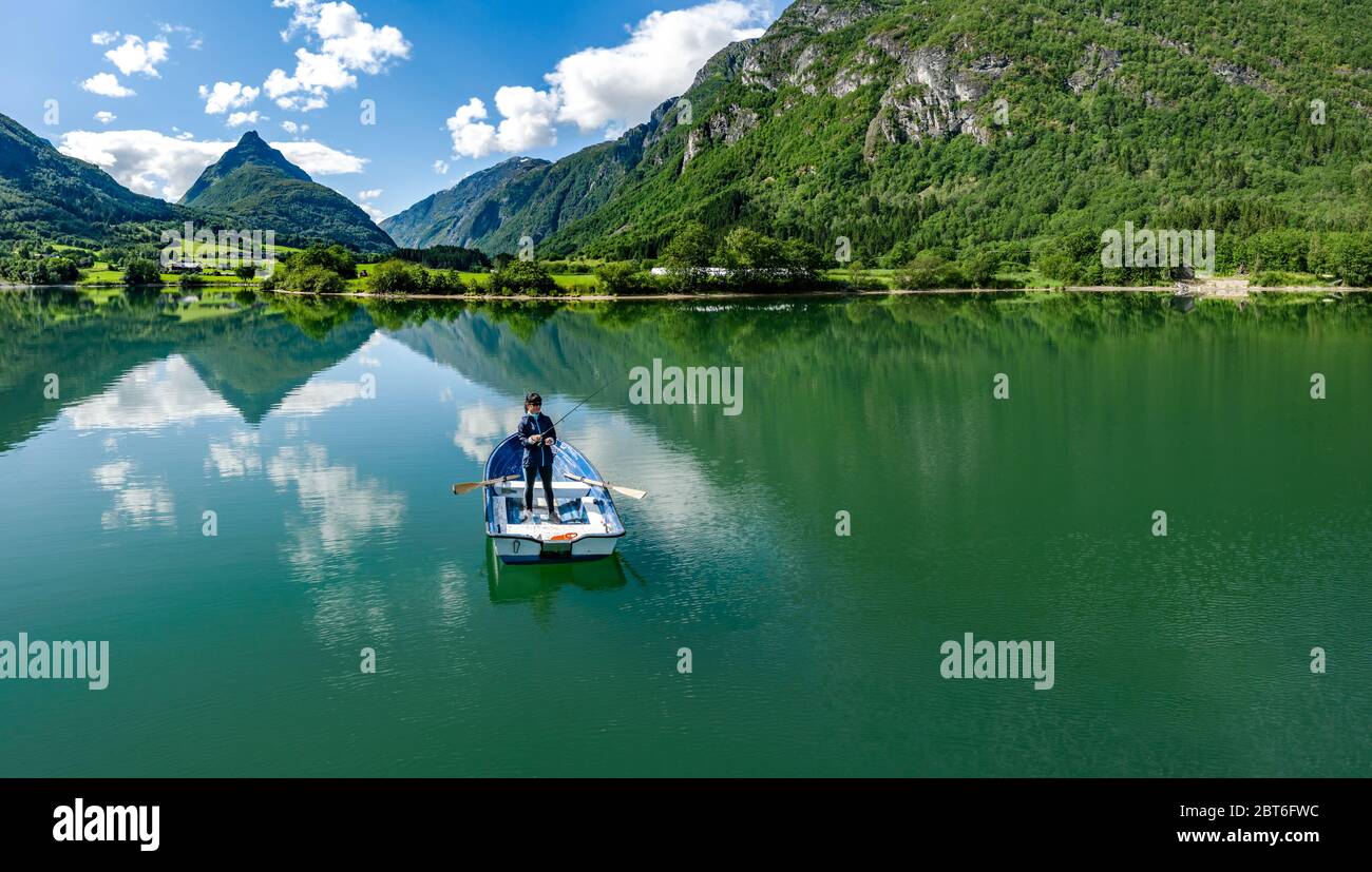 Woman fishing on a boat. Beautiful Nature Norway natural landscape ...