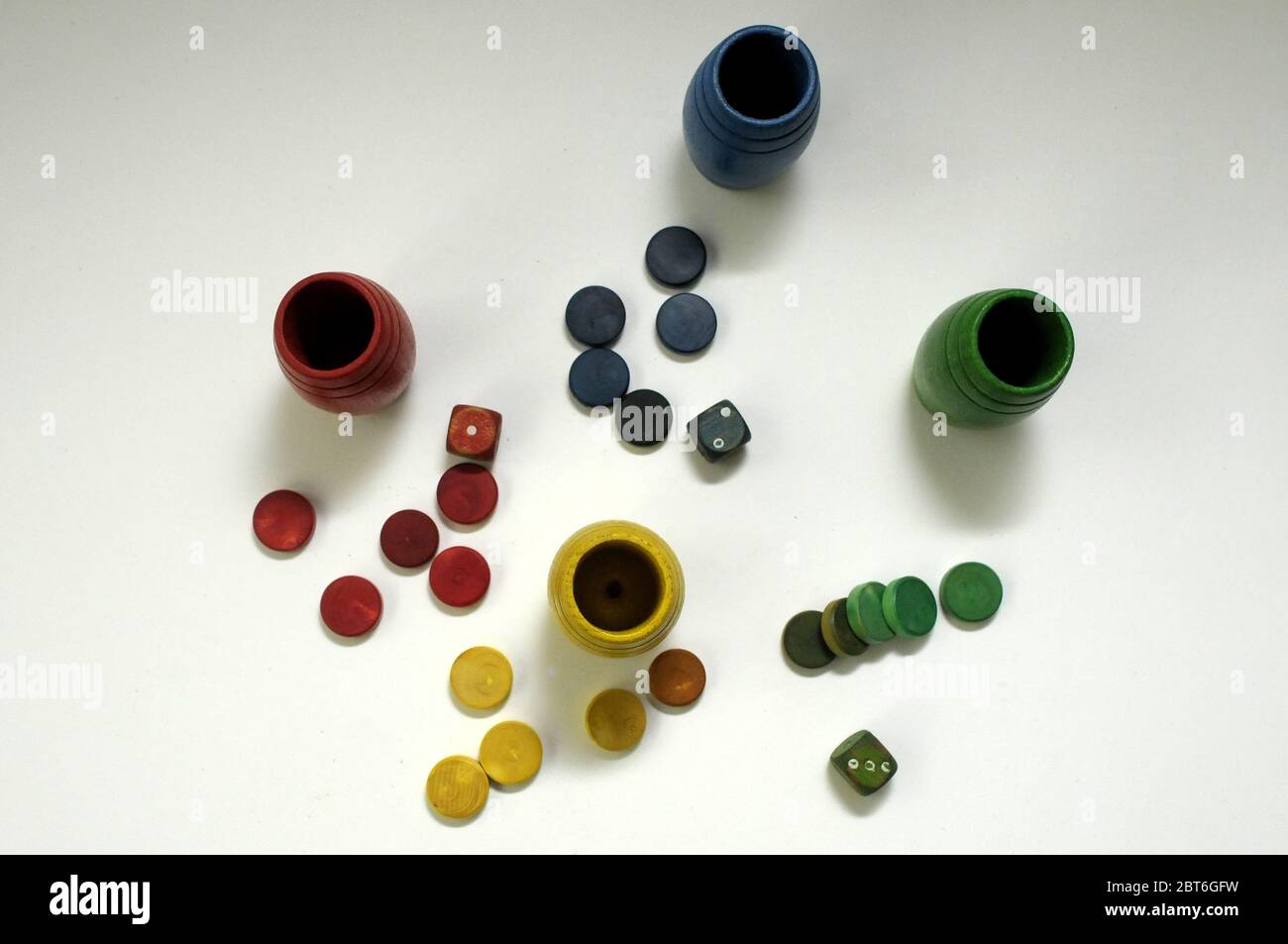 Parchis game, dice, goblets, colored chips on wood, red, yellow, blue ...