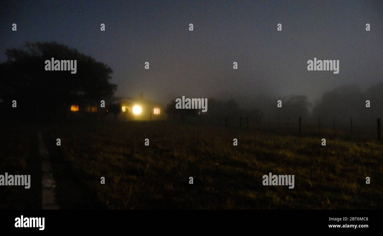 Farmhouse Lights Shining Through Mist Stock Photo - Alamy