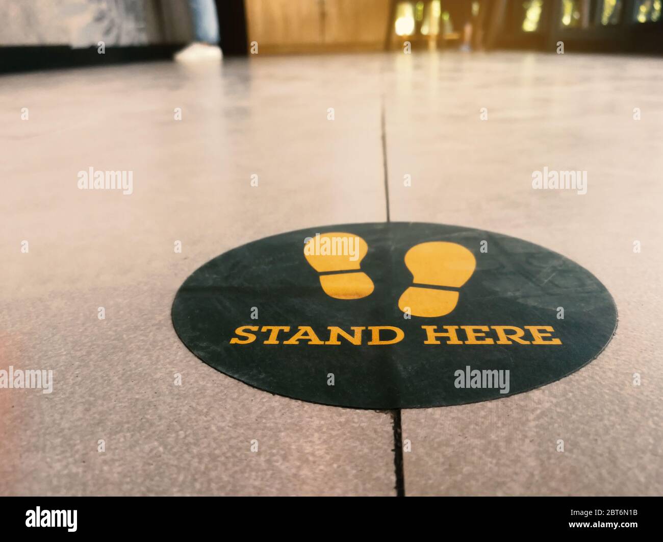 Stand here foot sign or symbol on the floor with the people is waiter ...