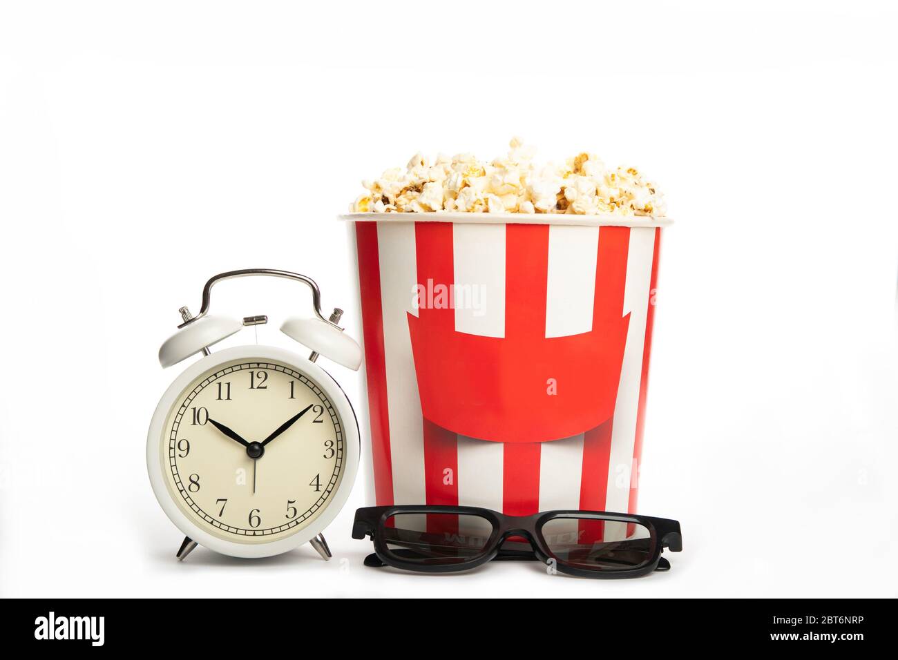 Paper cup with popcorn, 3D glasses and an alarm clock isolated on a ...