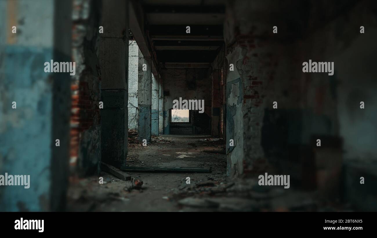 Long corridor of ruined abandoned eerie pillar industrial building with ...