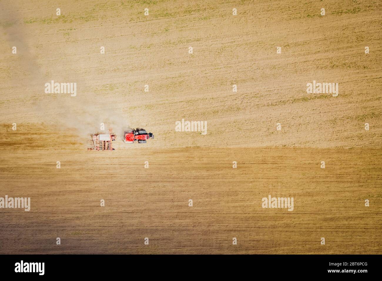 A tractor plows fields for sowing crops. View from above. Tractor in ...