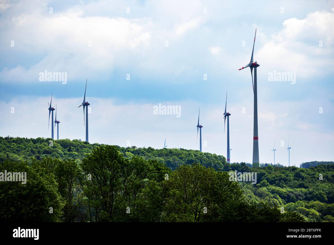 large piece of forest and in the middle of it a large wind farm with ...