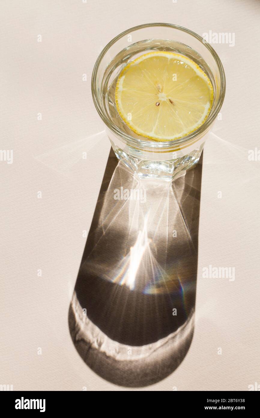 Top view glass of water with lemon slices on beige background with ...