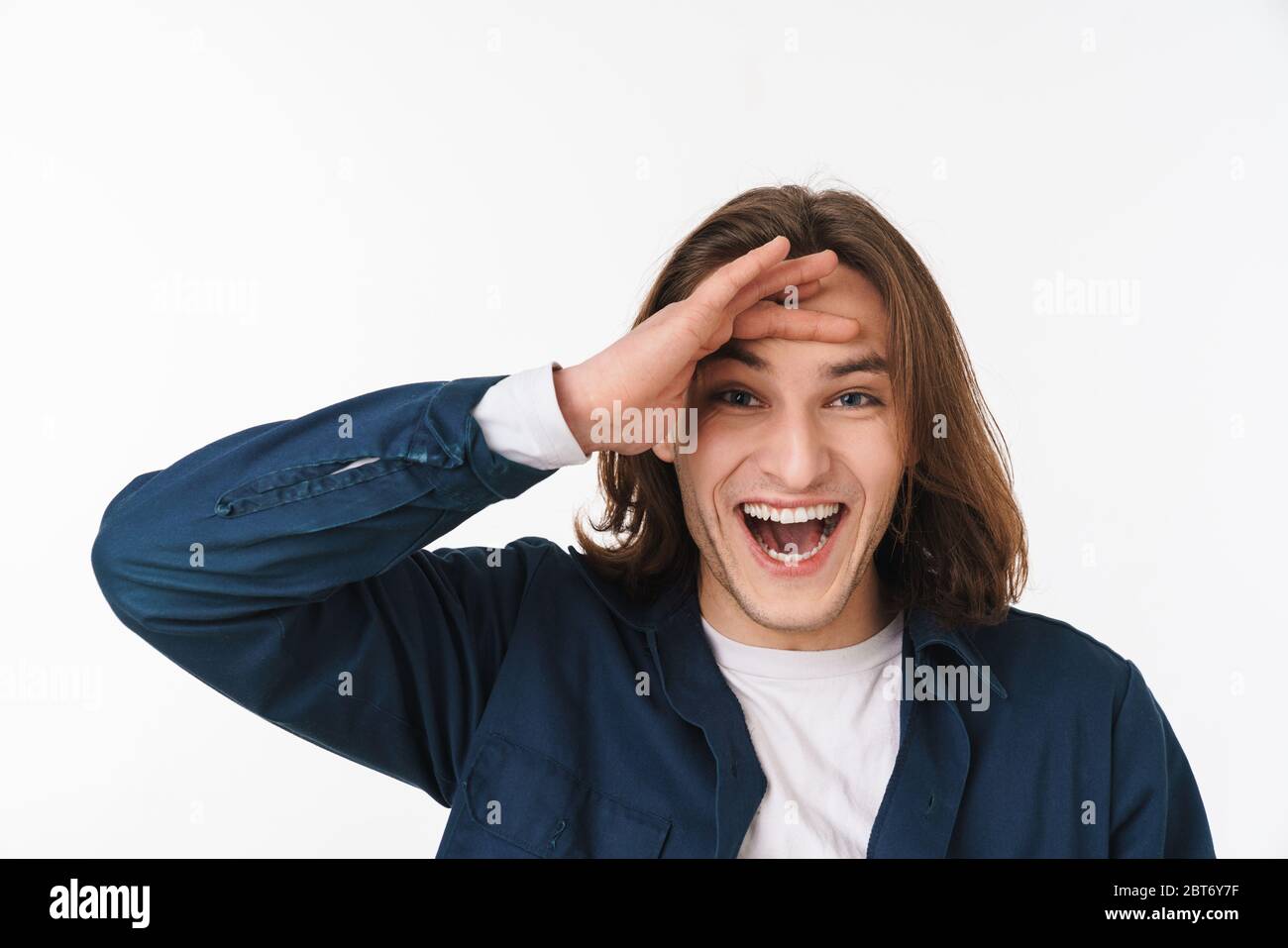 Image of happy young man with long hair smiling and expressing surprise ...