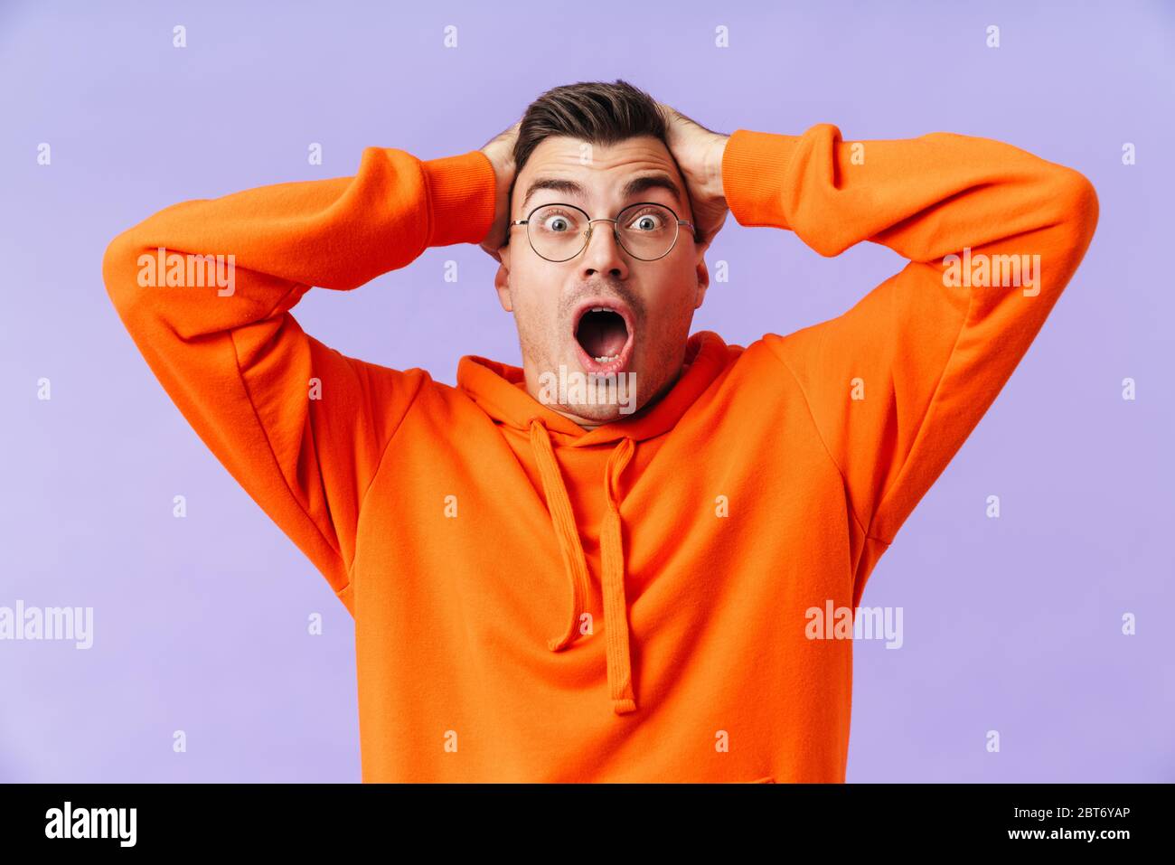 Photo of shocked screaming young man isolated over purple background ...