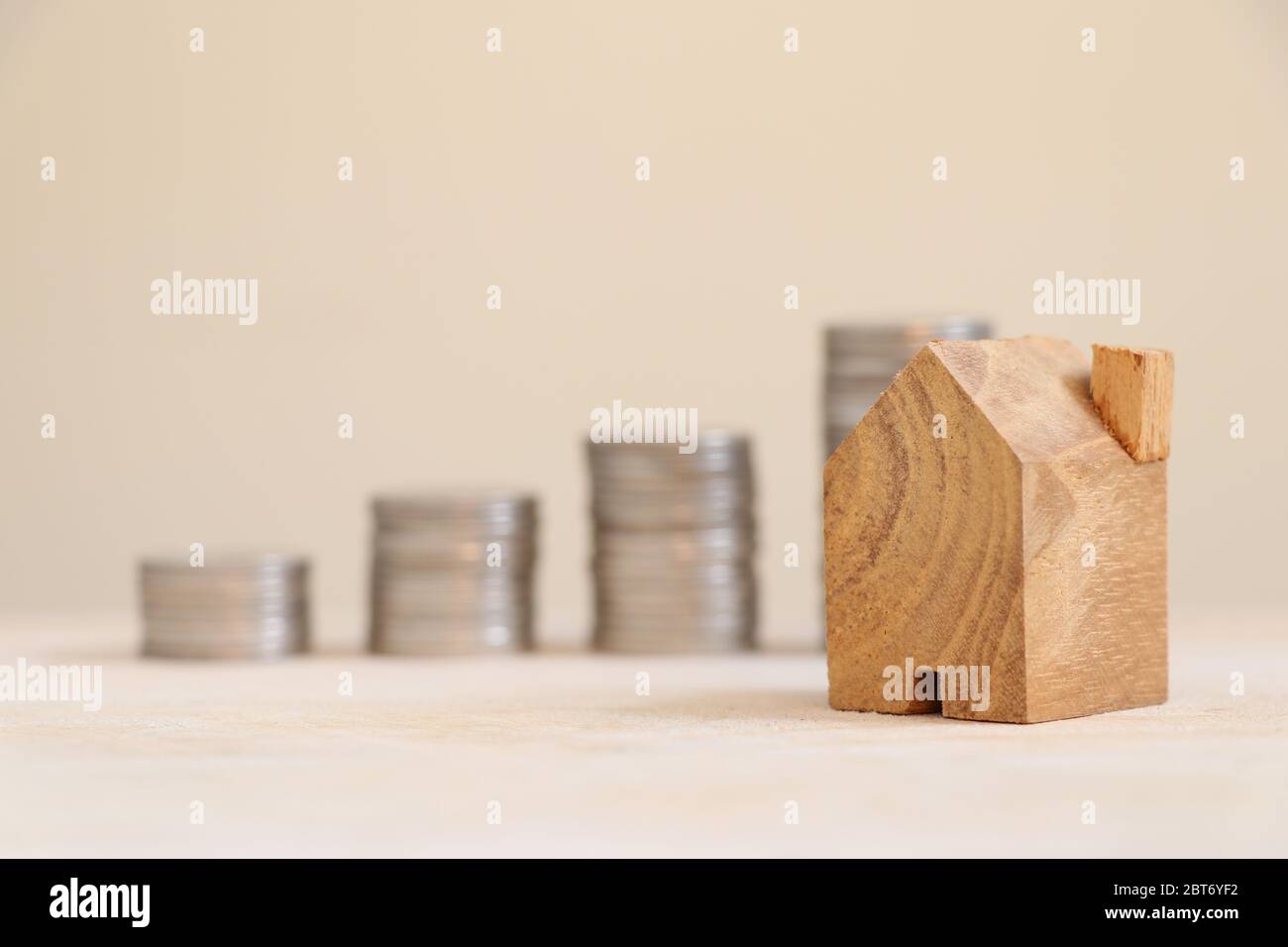 Wooden home model with blurred coins bar graph background Stock Photo ...