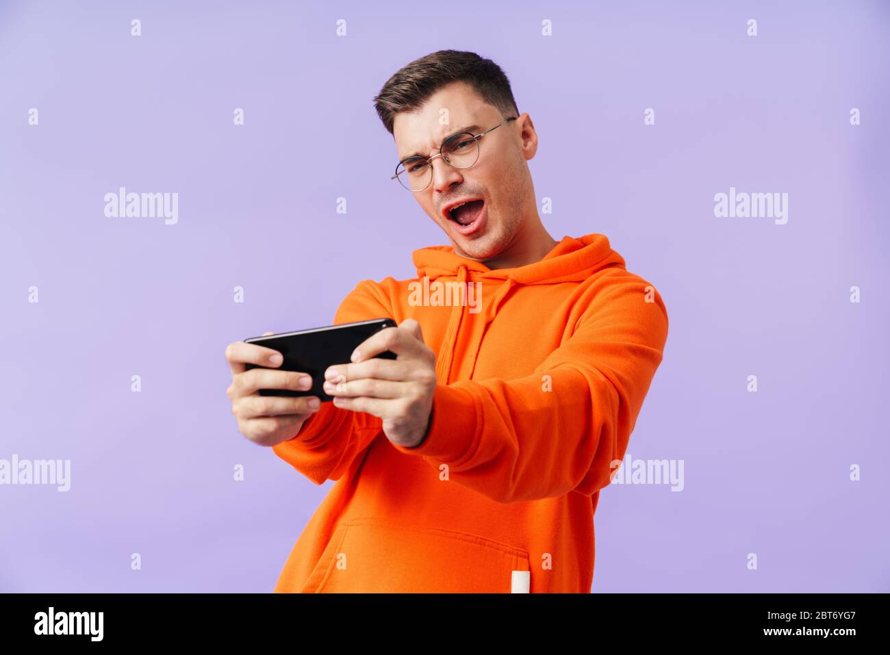 Portrait of emotional concentrated screaming young man posing isolated ...